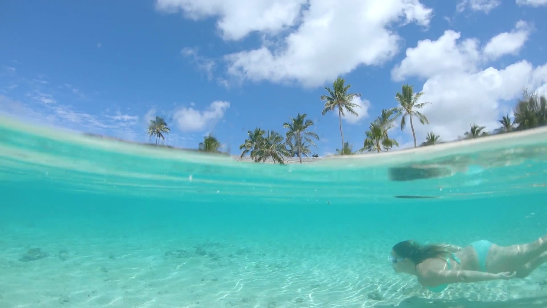 半水下 年轻女子在令人叹为观止的水晶般清澈的水中浮潜。_模板素材-稿定设计